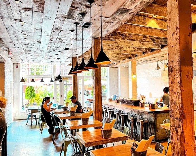 Rustic wooden beams meet modern design in this airy space. Like a New England boathouse that went to art school and came back cooler.