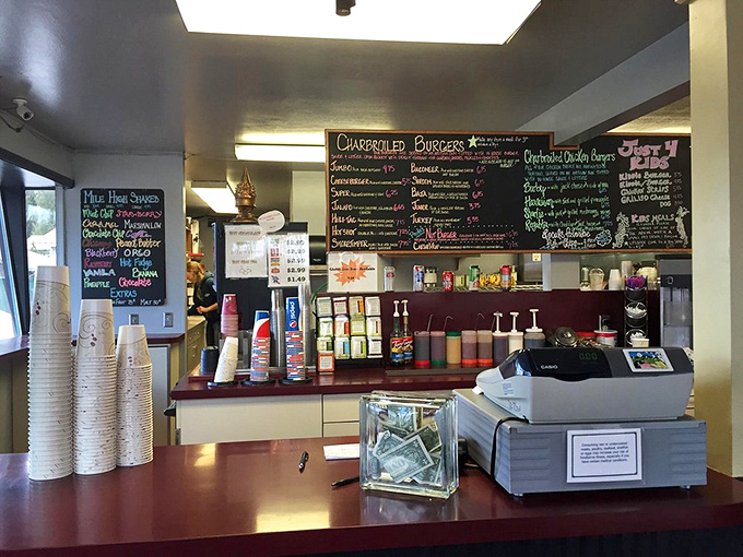 The chalkboard menu tells stories of burger possibilities while the tip jar patiently waits. This counter has witnessed countless "I'll have the usual" moments.
