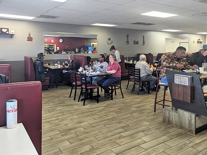Inside, burgundy booths and wood-toned warmth create the perfect backdrop for conversations that flow as freely as the coffee.