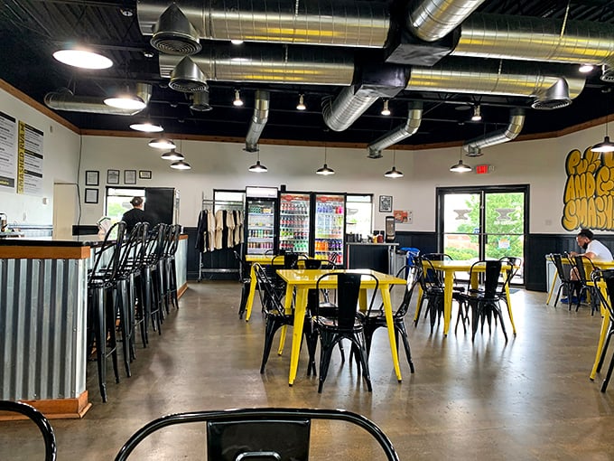 Industrial chic meets burger joint functionality – those yellow tables practically scream "something delicious is about to happen here!"