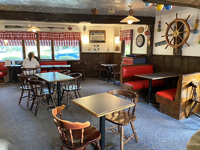 Nautical charm meets no-nonsense comfort inside the Clam Box. Ship wheels, red booths, and wooden accents create the perfect backdrop for seafood feasting.