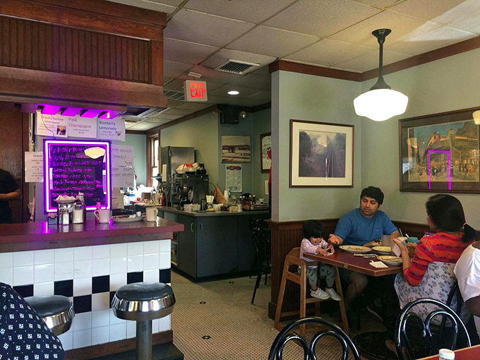 Inside, the classic diner aesthetic comes alive with wood paneling, checkered floors, and that unmistakable purple glow announcing daily specials that locals swear by.