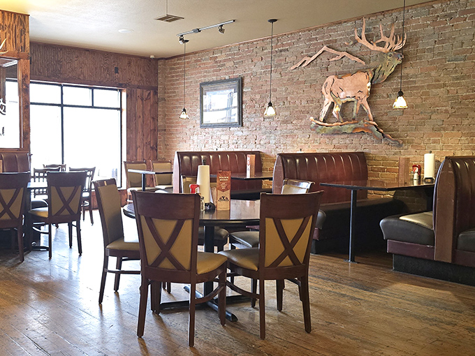 Exposed brick walls meet wooden elk mounts in this dining room that feels like the living room of your hunting-obsessed friend who secretly went to culinary school.