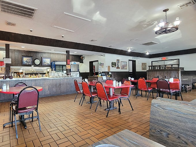 Inside, red chairs and wood paneling create that perfect small-town diner atmosphere where conversations flow as freely as the coffee.