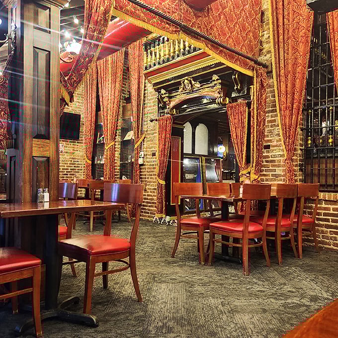 Step into what can only be described as a culinary theater, where red velvet curtains frame your dining experience like the main event it truly is.