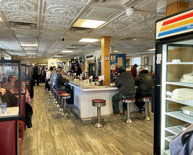Classic diner perfection: chrome stools, wooden floors, and those gorgeous pressed tin ceiling tiles that have witnessed countless conversations.