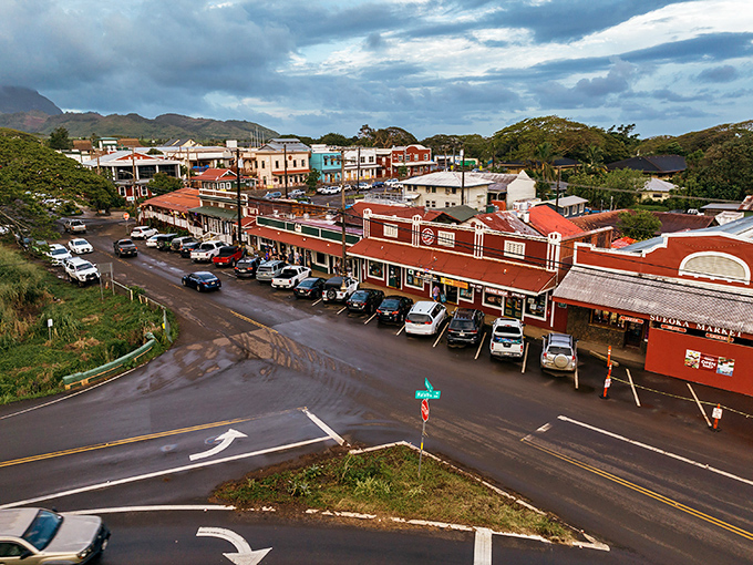 From this bird's-eye view, Old Koloa Town reveals itself as a perfectly preserved postcard of plantation-era Hawaii, nestled against the dramatic backdrop of Kauai's mountains.