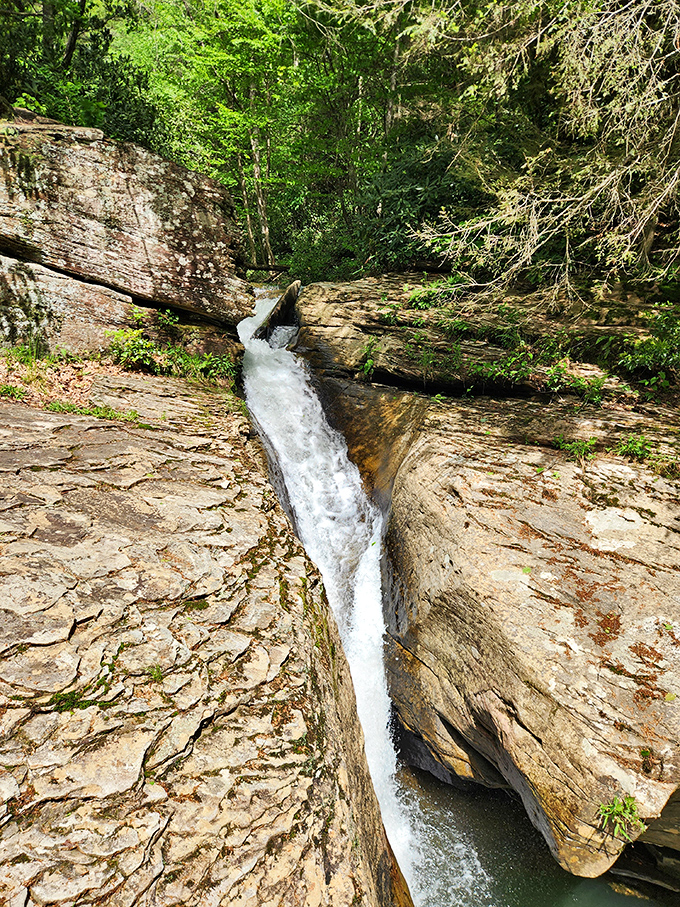 Water carves its own masterpiece through ancient stone, creating a natural water slide that beckons the adventurous soul.