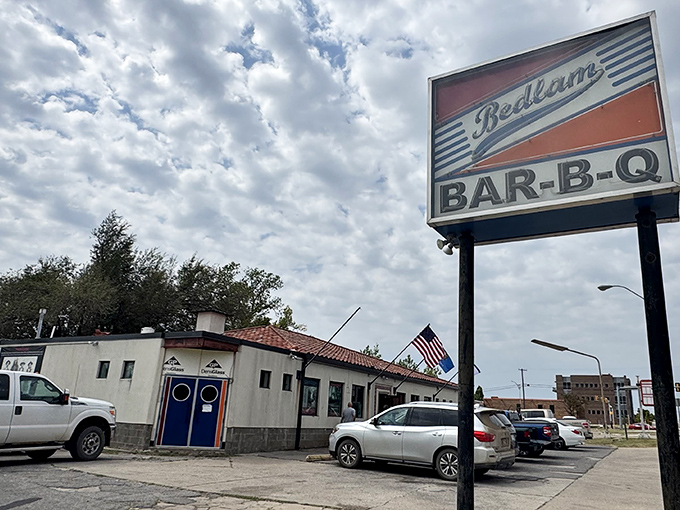 The classic Bedlam BAR-B-Q sign stands tall against Oklahoma skies. This unassuming spot has been converting BBQ skeptics for years.