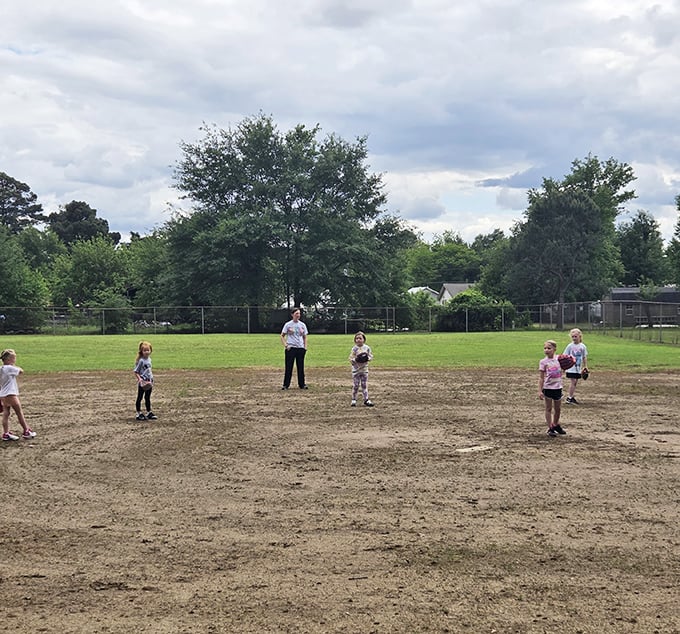 Kids playing ball on actual dirt, getting gloriously messy in ways that would horrify helicopter parents everywhere.