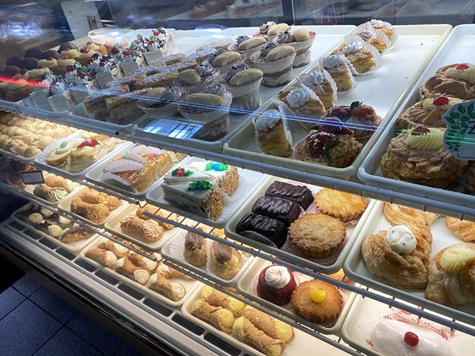 Dessert heaven awaits behind glass &ndash; each tray a masterpiece, each pastry a reason to abandon all diet resolutions immediately.