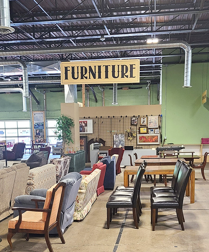 "FURNITURE" proclaims the sign, presiding over an eclectic parliament of sofas, chairs, and tables awaiting adoption.