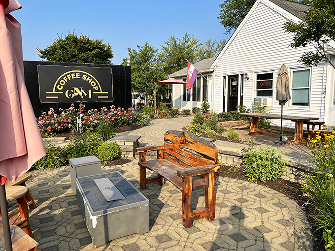 GNM Coffee Shop's garden patio invites lingering conversations over steaming mugs, where wooden benches and blooming flowers create retirement's perfect morning office.