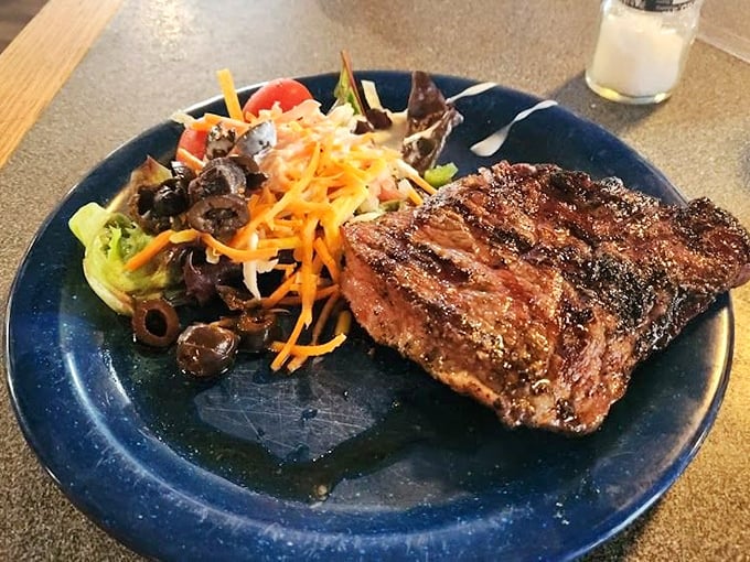 This isn't just steak; it's a carnivore's sonnet—perfectly seared, seasoned, and served alongside a colorful salad that's trying its best to matter.
