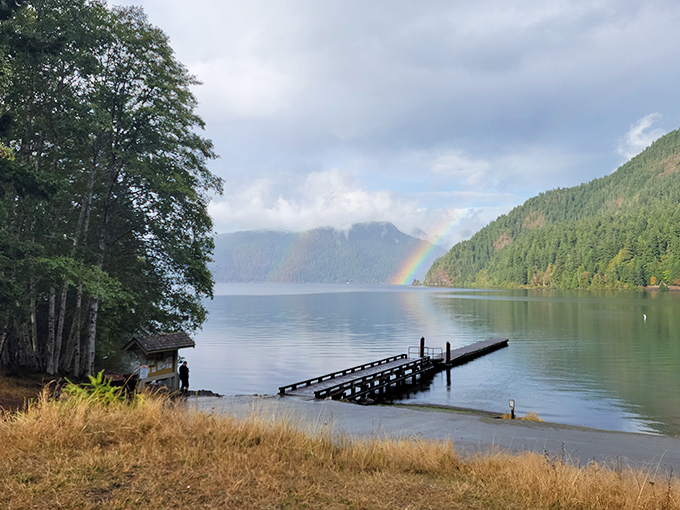 Nature's own meditation spot – this weathered pier stretches into Lake Crescent's crystal waters while a rainbow adds that touch of Pacific Northwest magic.