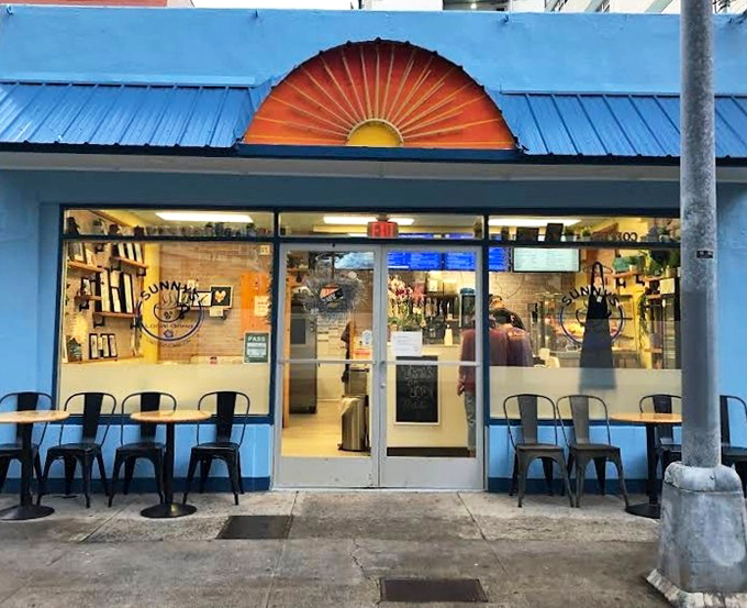 Sunny's bright blue walls and sunset logo are like a permanent good morning. That half-circle window design is practically winking at you.