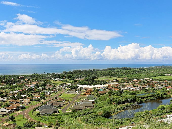 Lush green fields and quiet Waimea neighborhoods stretch toward the shimmering ocean, all resting under Hawaii&rsquo;s wide blue sky and rolling clouds.