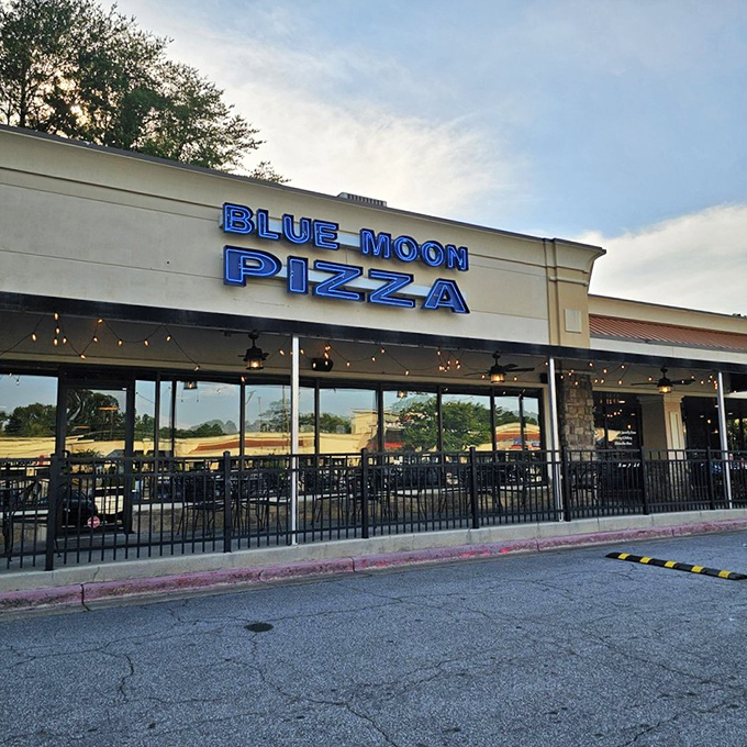 Blue Moon Pizza's welcoming patio and bright signage stand ready for hungry visitors &ndash; a suburban oasis where cheese dreams come true.