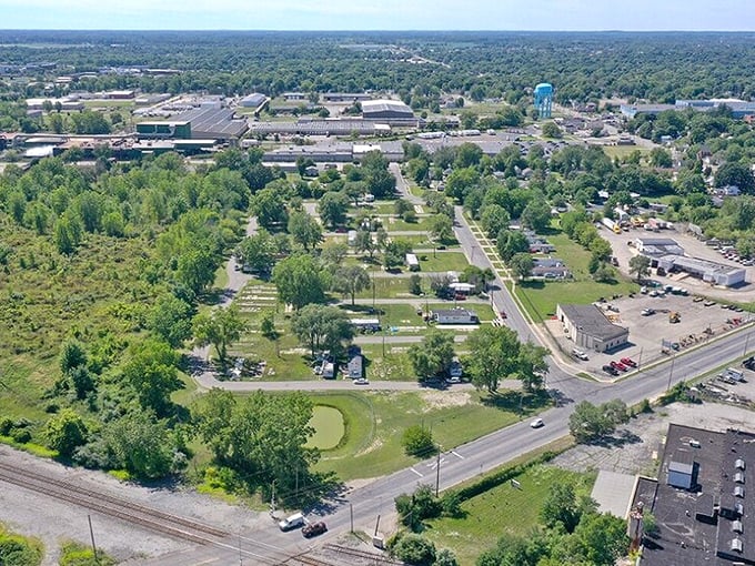 Aerial view of Adrian, Michigan showing residential neighborhoods, green spaces, and industrial areas with tree-lined streets.