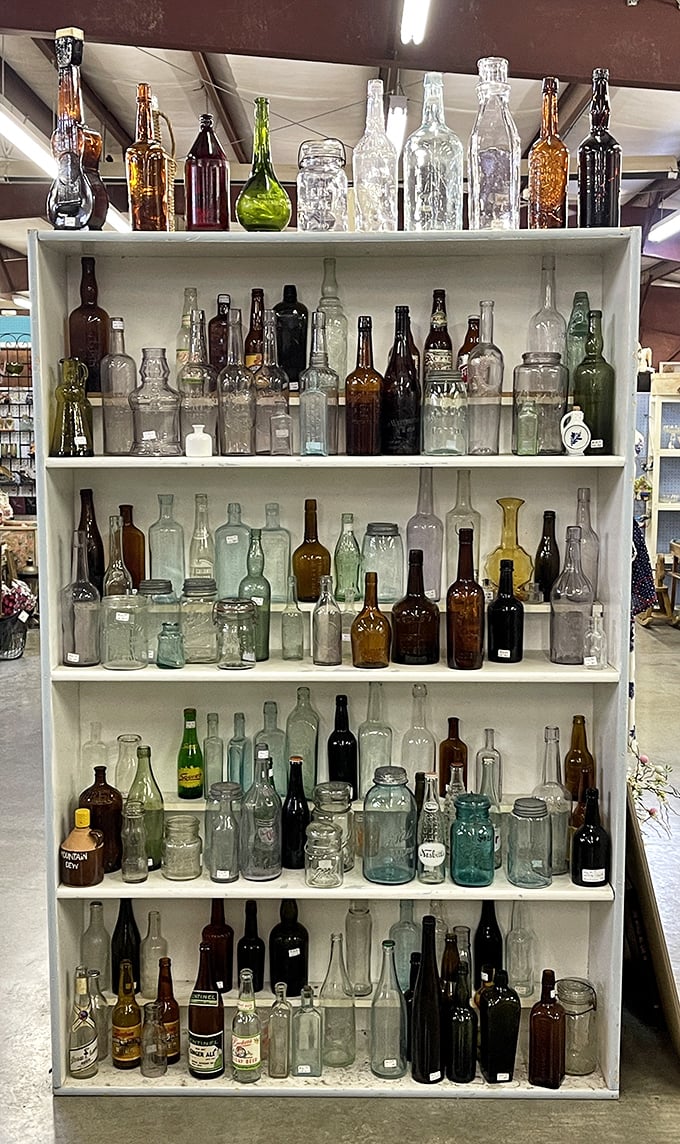 A rainbow of vintage glass catches the light like liquid history. Each bottle whispers tales of bygone beverages and medicine cabinet curiosities.