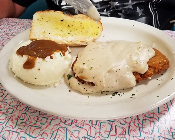Country-fried steak smothered in creamy gravy alongside fluffy mashed potatoes—a plate that doesn't just feed your hunger but hugs your soul.