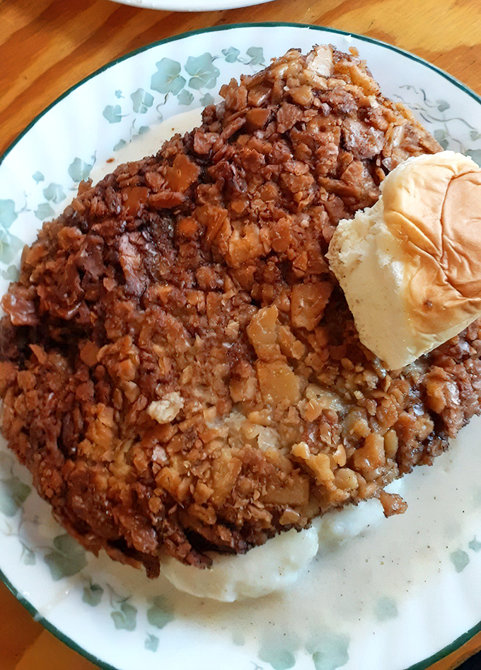 Behold the star attraction—chicken fried steak with a golden crust that shatters like glass, smothered in gravy that could make a vegetarian weep.