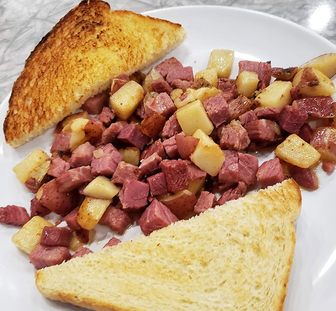 Behold the star of our show: chunks of slow-roasted corned beef mingling with perfectly diced potatoes. This isn't just breakfast&mdash;it's a meaty masterpiece with golden toast sentries.