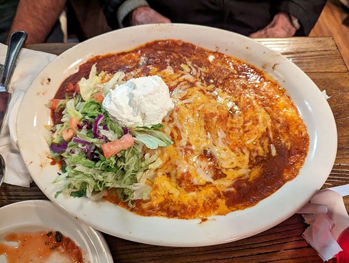 Behold the star attraction: enchiladas swimming in that glorious red sauce, topped with cheese that doesn't just melt&mdash;it performs.