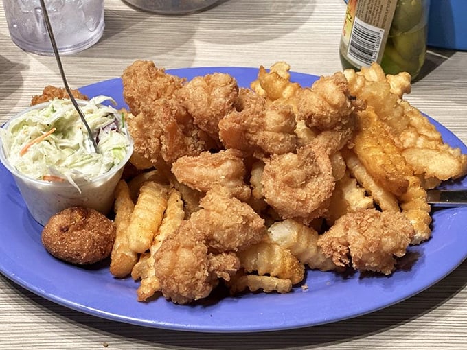 Golden-fried treasures from the Gulf piled high on a blue plate. This isn't just dinner—it's edible sunshine that makes you understand why people vacation in Alabama.