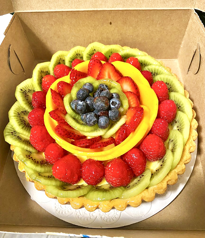 Behold fruit tart perfection! Geometrically arranged kiwi, strawberries, and blueberries glisten like jewels in a pastry crown fit for royalty.