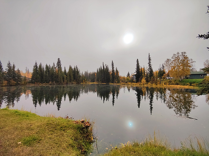 Mirror-like waters reflect North Pole's autumn splendor, creating nature's perfect symmetry. Even Santa needs a peaceful spot to contemplate his naughty-or-nice list.