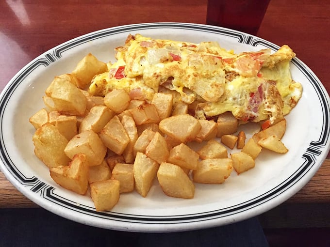This omelet and home fries combo isn't just breakfast&mdash;it's edible sunshine on a plate with golden potato cubes.