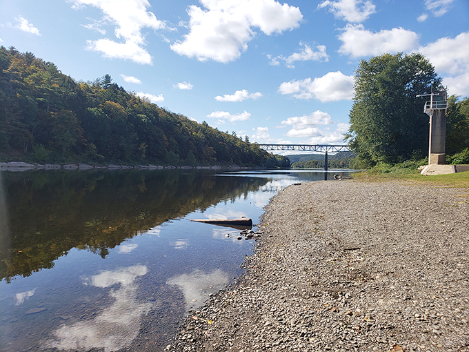 The Delaware River's edge offers a peaceful respite where clouds reflect in the water and your worries drift downstream like fallen leaves.