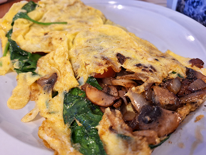 Behold the humble omelet, transformed into an art form where spinach and mushrooms peek out like they're playing hide-and-seek with your taste buds.