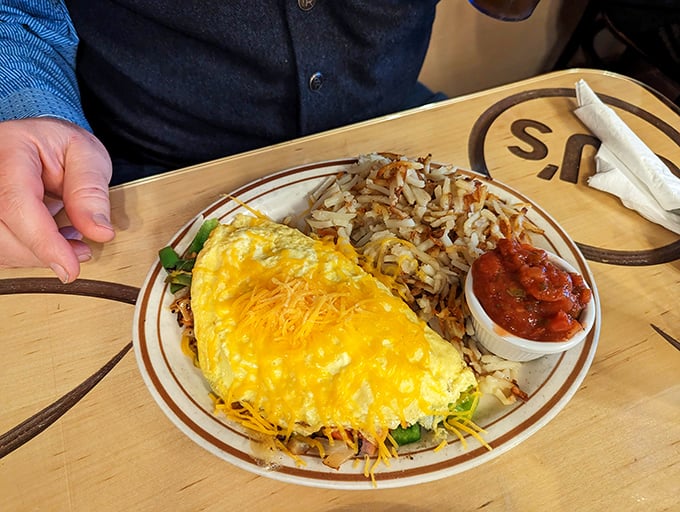 Behold the Spanish omelet in all its glory &ndash; a golden pillow of eggs cradling cheese and veggies, with crispy hash browns standing guard alongside.