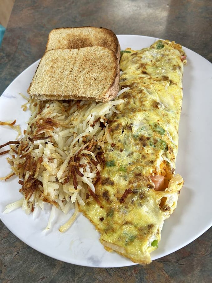 This omelet defies physics – somehow managing to be both substantial and delicate, with hash browns crisped to golden perfection.