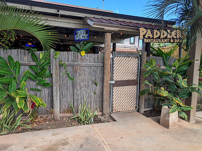 Paddlers Restaurant's bamboo entrance promises island flavors and cold drinks behind its unassuming tiki-inspired gate.