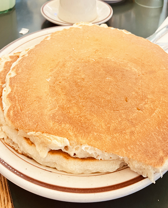 Behold the pancake that launched a thousand road trips. Golden, fluffy, and approximately the size of a small Wyoming county.