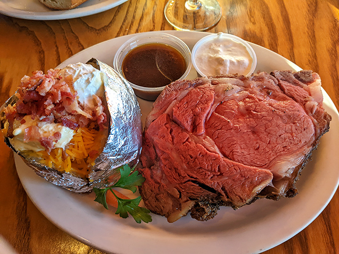Behold the star of the show: prime rib so perfectly cooked it practically poses for its portrait, accompanied by a loaded baked potato.