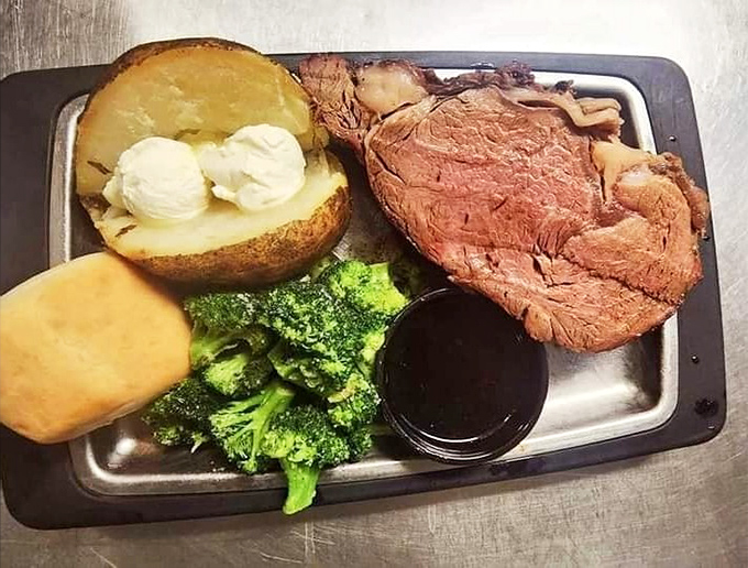 Prime rib so perfectly executed it deserves its own Netflix special, accompanied by a baked potato that's dressed better than most people at formal events.