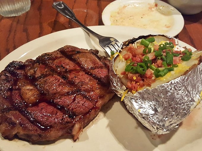 This perfectly charred ribeye isn't just dinner; it's a religious experience with grill marks. The loaded potato plays a worthy supporting role.