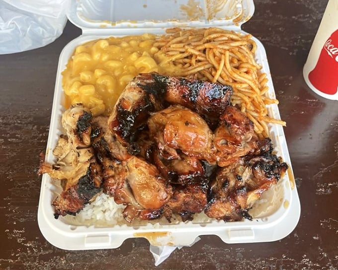 Bourbon chicken nestled on a bed of rice with mac and cheese and noodles. This styrofoam container holds more comfort than most five-star restaurants.