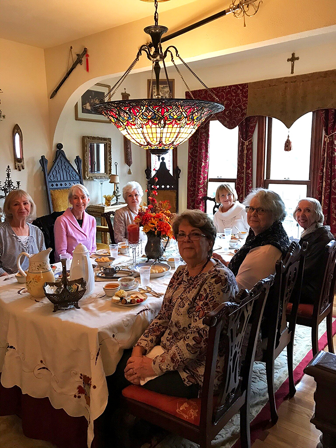 Ladies gathering for tea in a castle dining room, because sometimes brunch requires battlements and chandeliers.