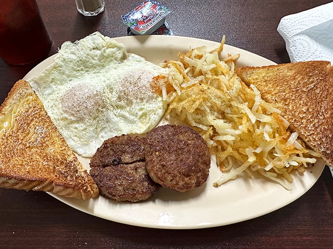 Breakfast perfection: crispy-edged eggs, golden hash browns, and sausage patties that would make your cardiologist wince but your soul sing.