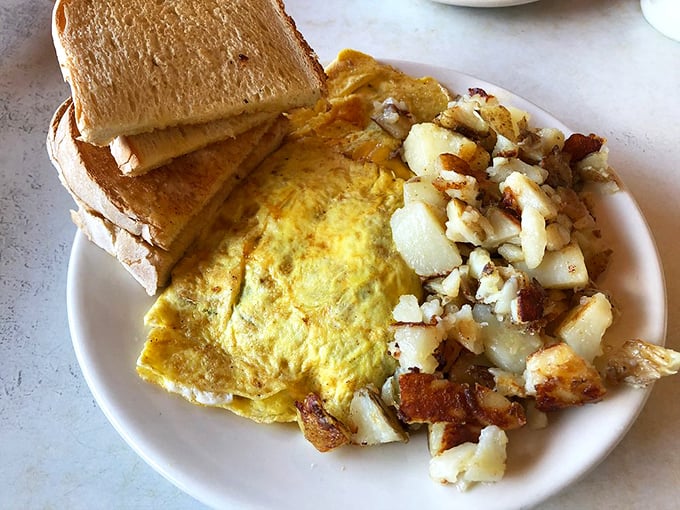 The breakfast trinity: perfectly folded omelet, golden toast, and home fries with just the right amount of crisp. Simple perfection on a plate.
