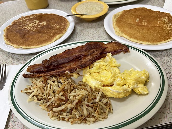Breakfast nirvana achieved: golden pancakes, perfectly scrambled eggs, crispy bacon, and hash browns that dance between crispy and tender.