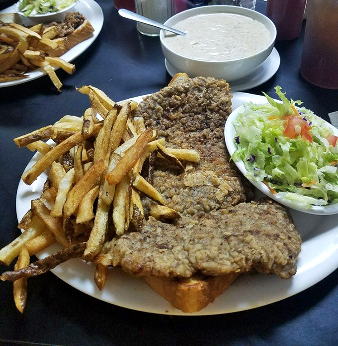 The legendary chicken fried steak spills over the plate's edges like Texas itself&mdash;boundless, golden, and unapologetically excessive.
