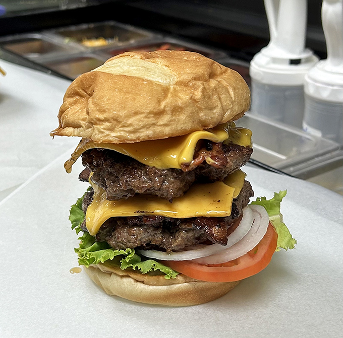 This towering burger masterpiece isn't just food &ndash; it's architecture, engineering, and art all stacked between two perfect buns.