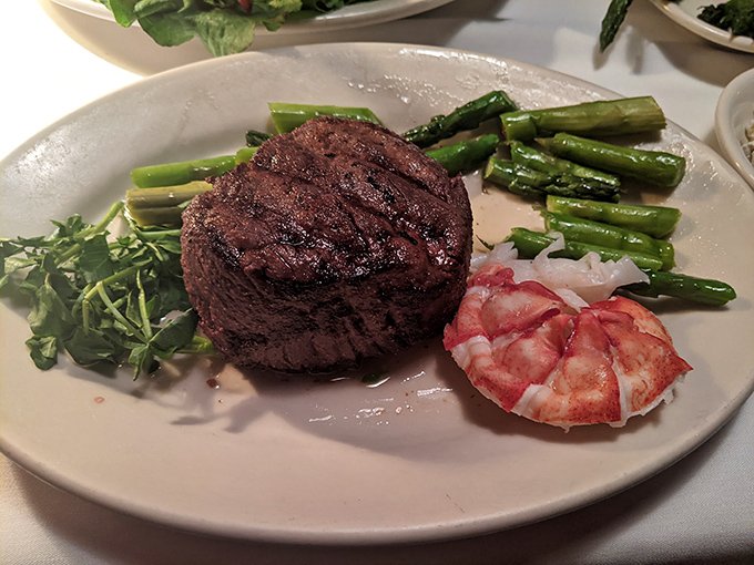 The filet mignon arrives like royalty, perfectly charred exterior giving way to a buttery-tender center. That lone shrimp? Just showing off.
