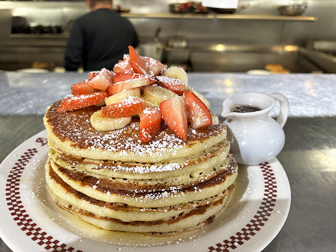 Behold the pancake tower of power &ndash; fresh fruit and powdered sugar crowning these golden discs of joy.